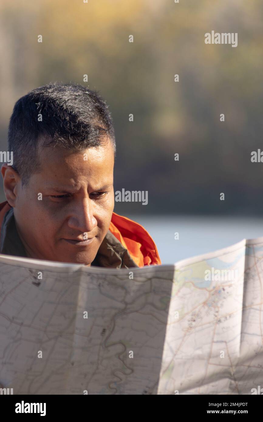 Portrait of traveler man at lake in autumn with a map. High quality ...