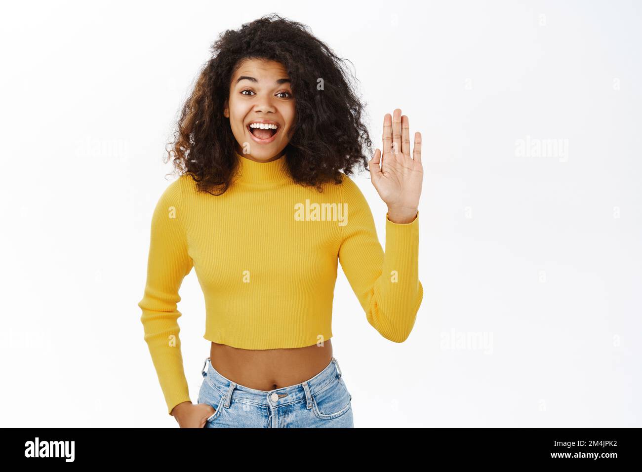 Friendly young african american woman saying hello, waving hand, say hi ...