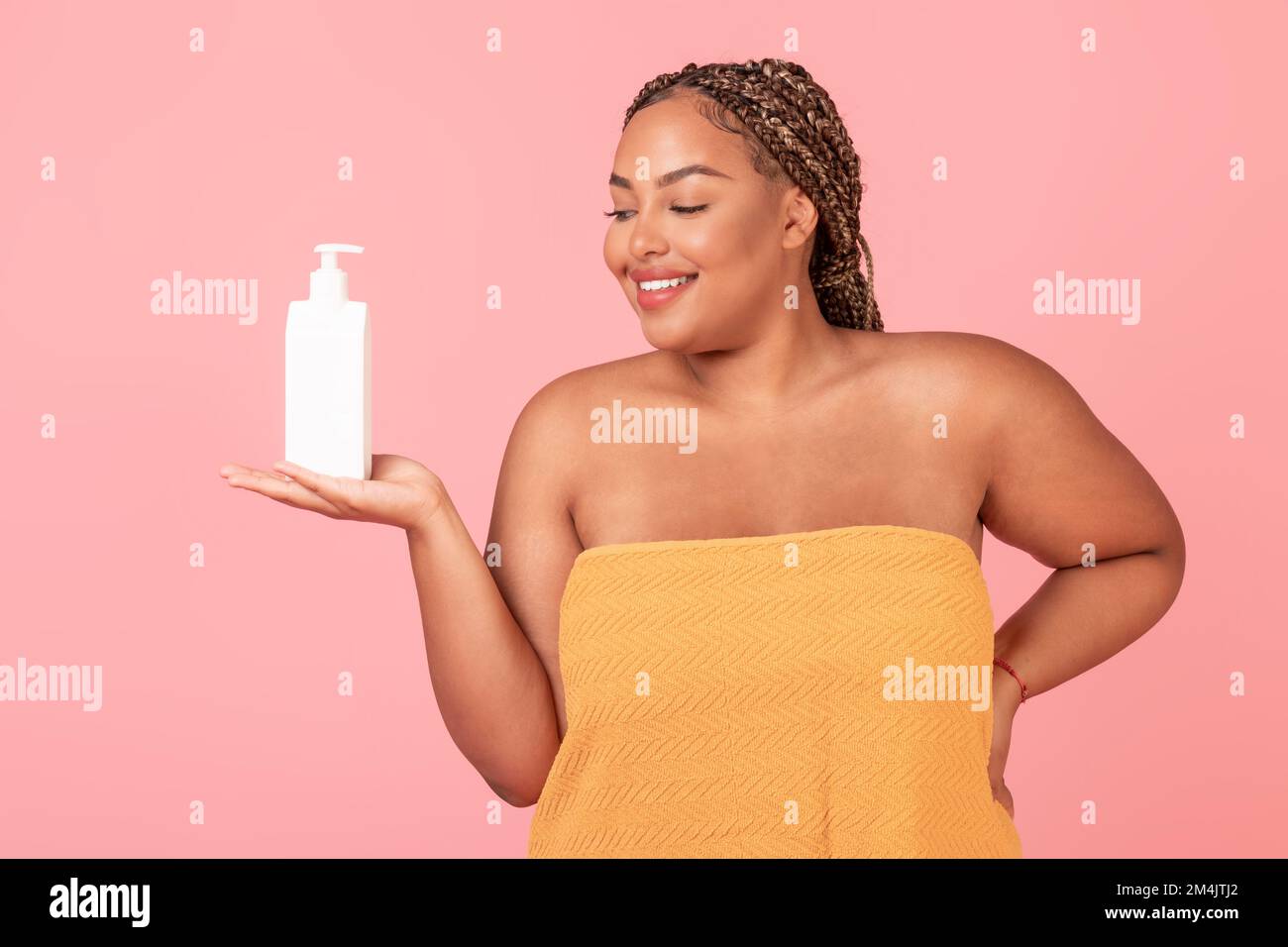 Beautiful black oversize woman holding bottle with body lotion ...