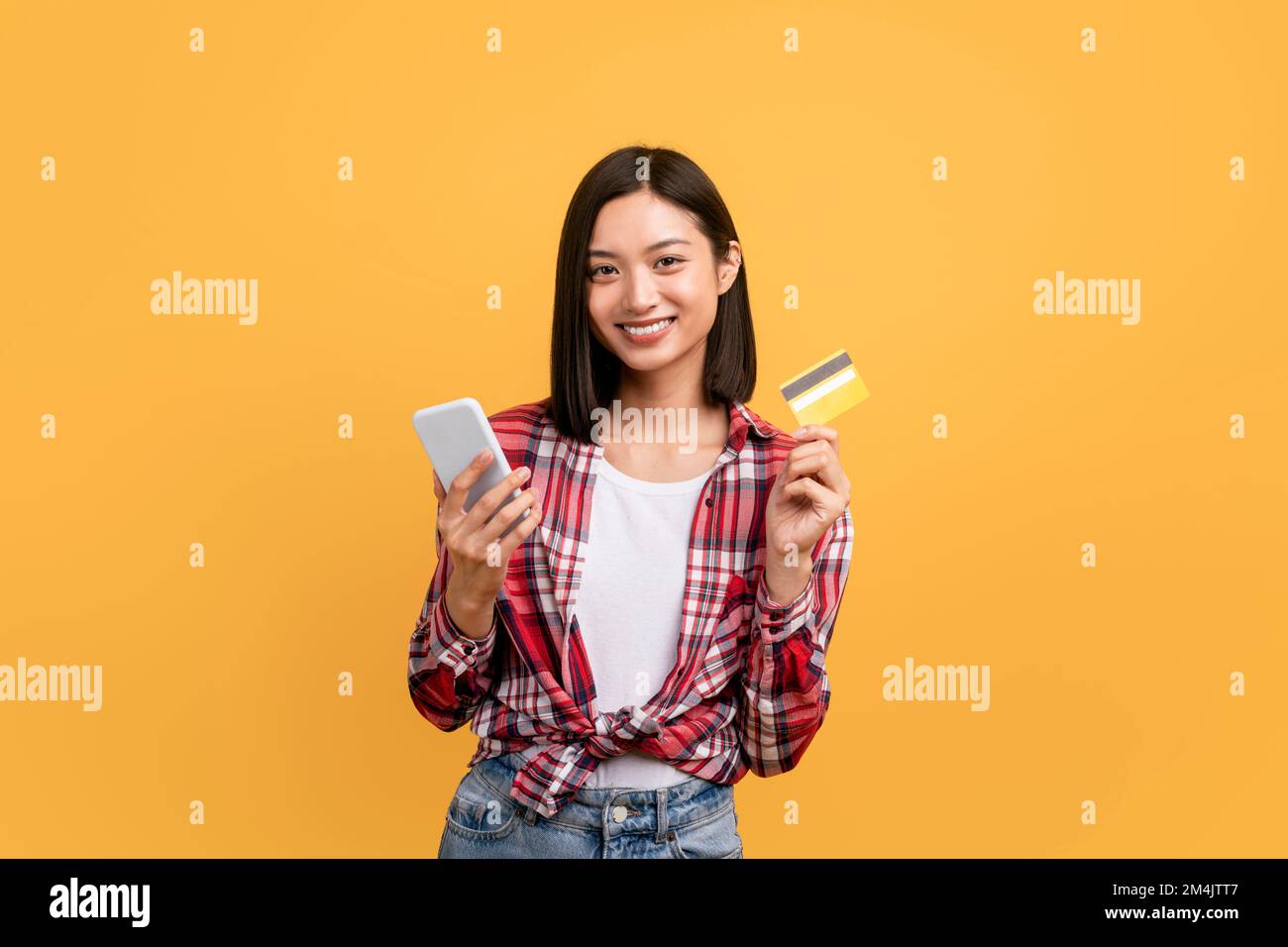 Easy money transfer. Happy young asian lady holding debit credit card ...