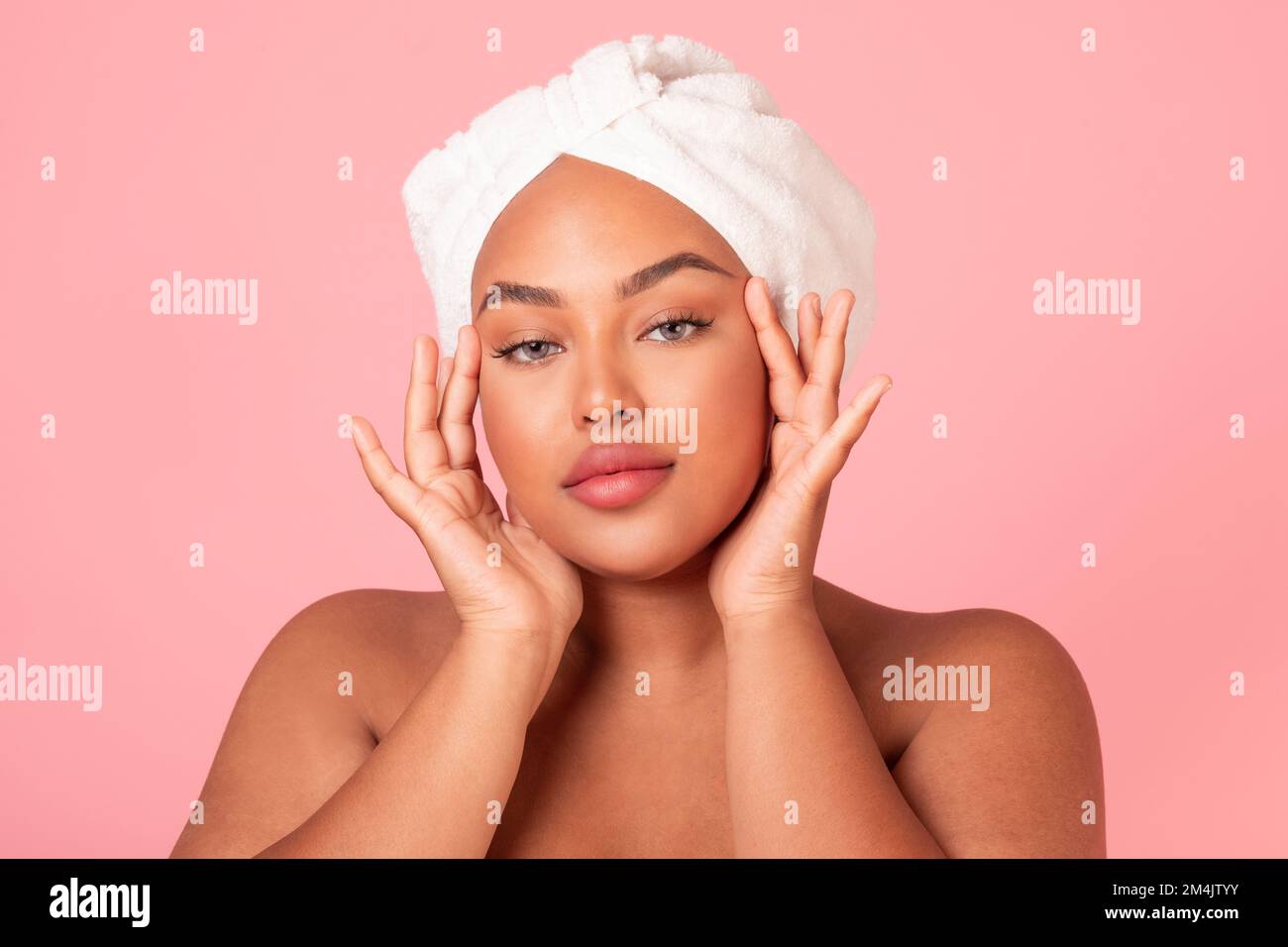 Attractive black body positive woman with smooth skin touching face and ...