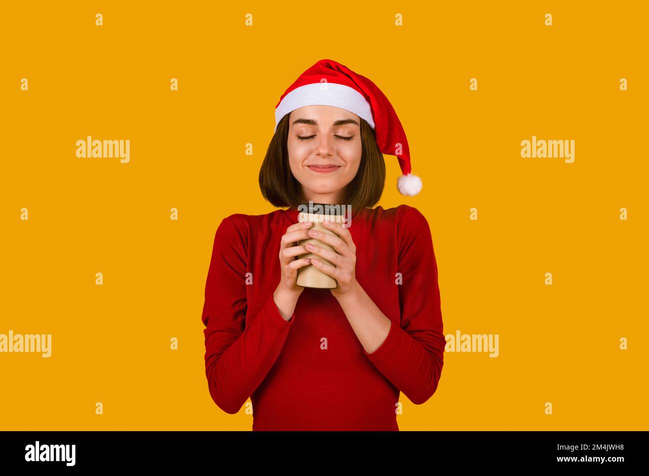 Happy young woman wearing Santa hat drinking smelling tasty cacao Stock ...