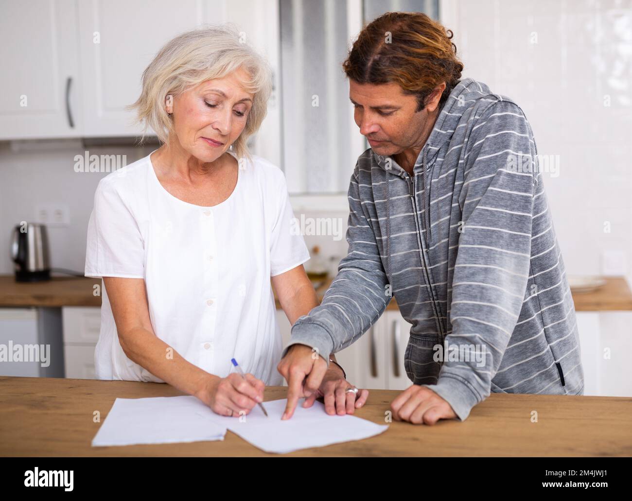 Mature woman and man doing paperwork together Stock Photo - Alamy
