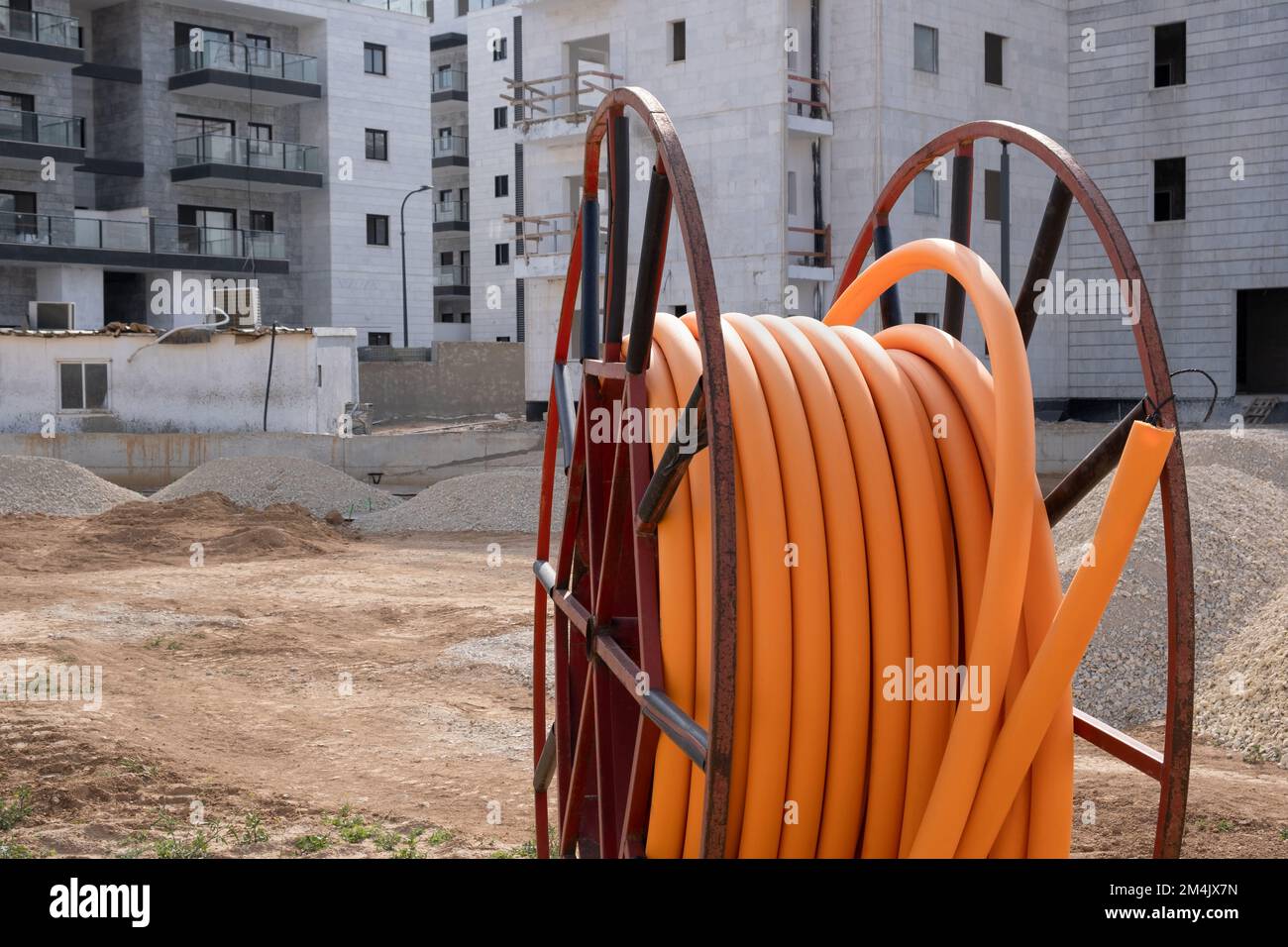 Communications development, Large coils reel of orange PVC pipe tube ...