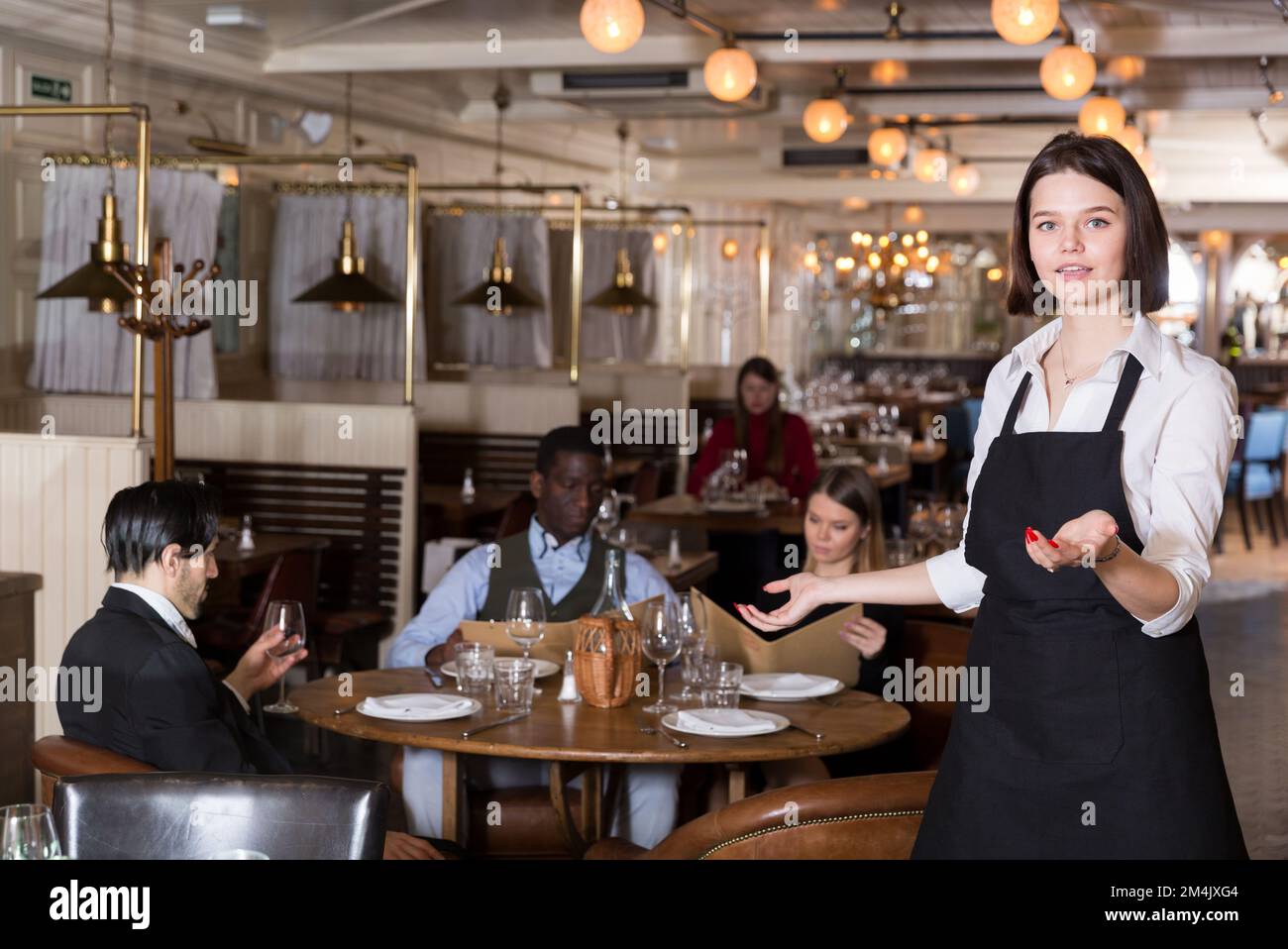 Smiling waitress welcoming to restaurant Stock Photo - Alamy