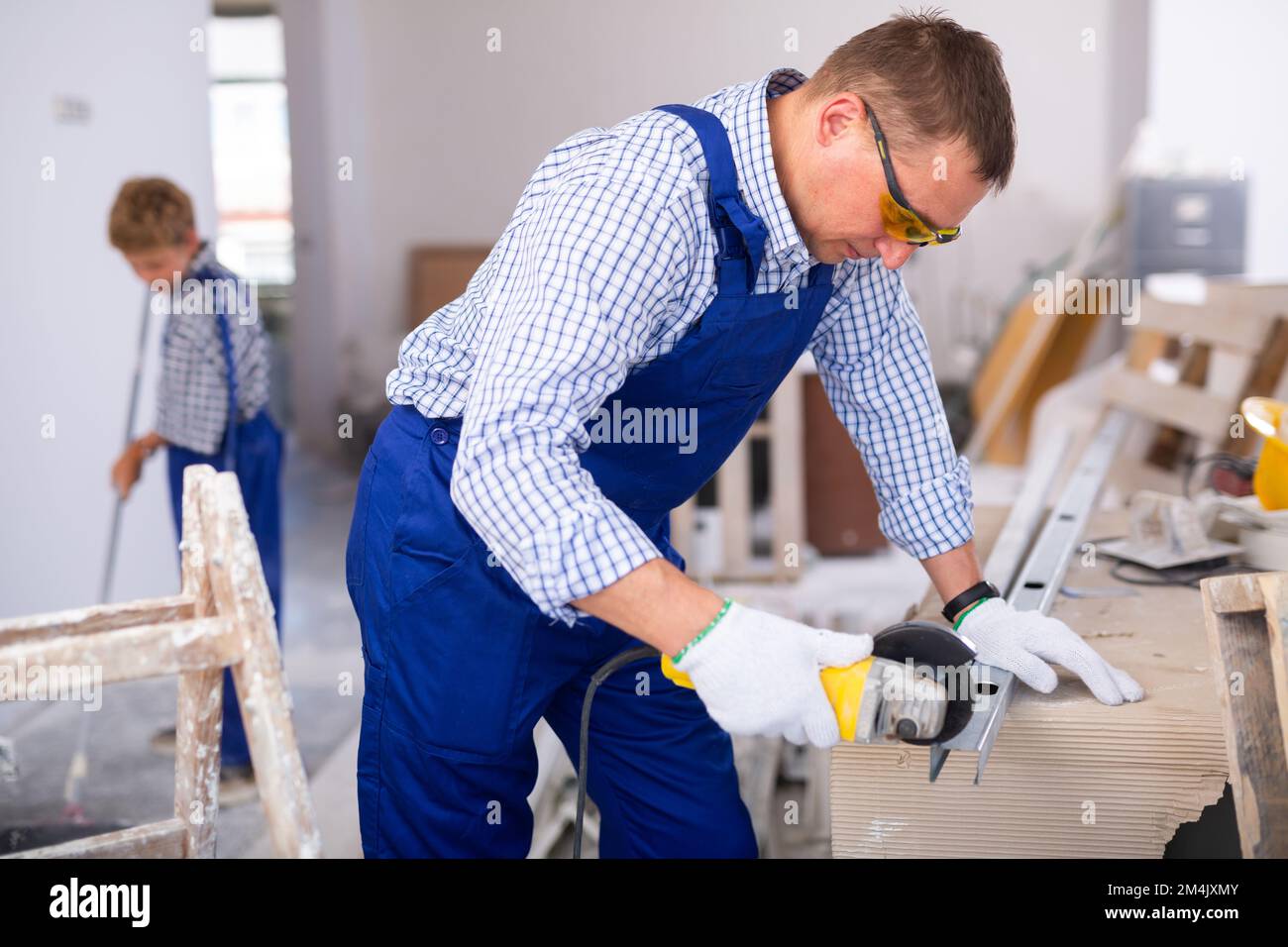 Man using disc saw to cut off metal plank Stock Photo - Alamy