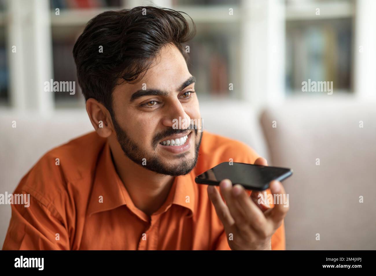Closeup of happy arab man recording voice mail on smartphone Stock ...