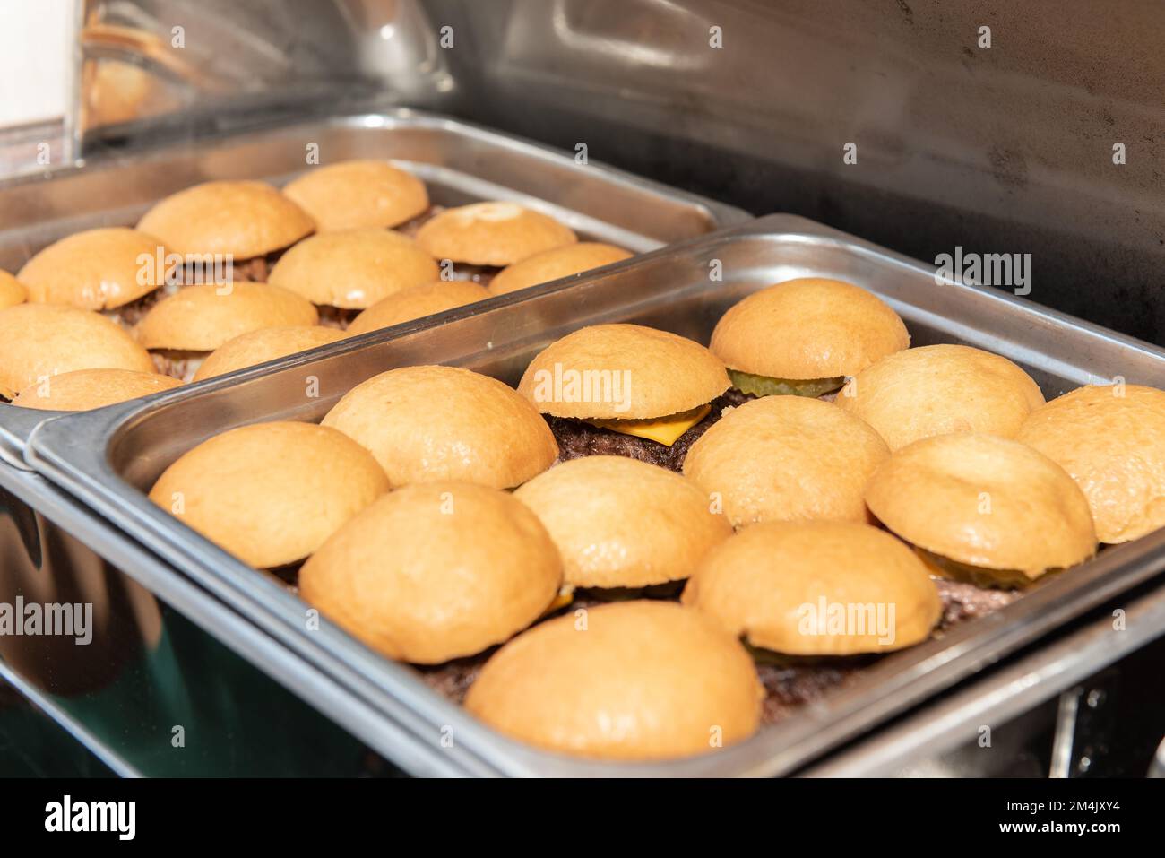 Buffet table with a chaffing dish full of cheeseburger sliders for the ...