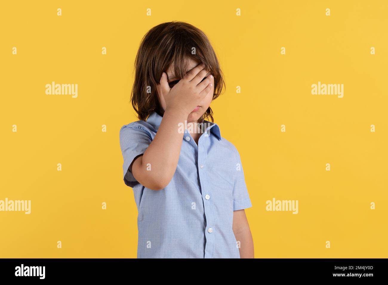 Disappointed cute little boy showing facepalm gesture, can't believe ...