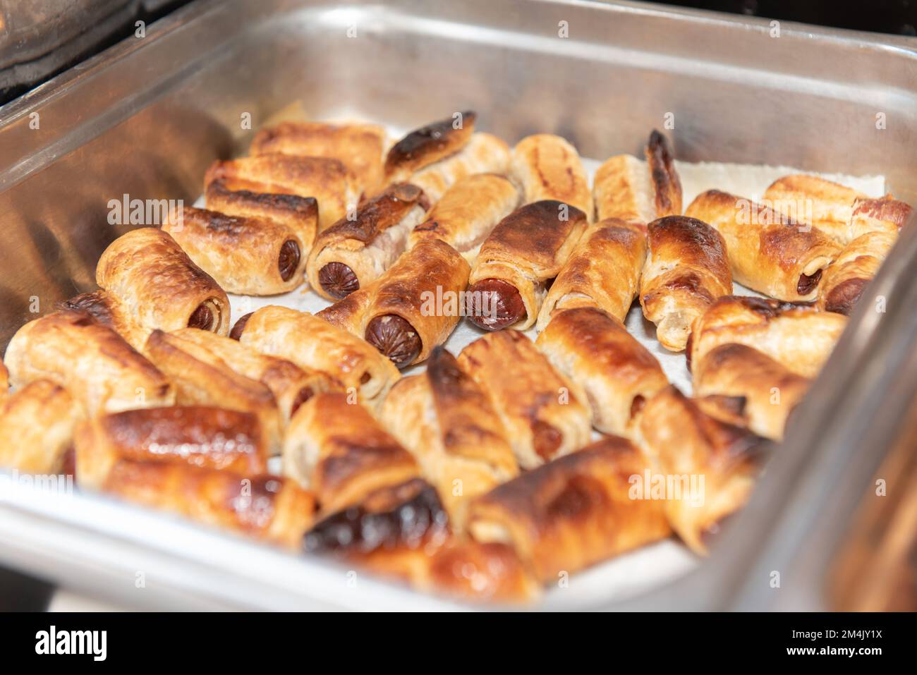 Buffet table with a chaffing dish full of wrapped pigs in a blanket for ...