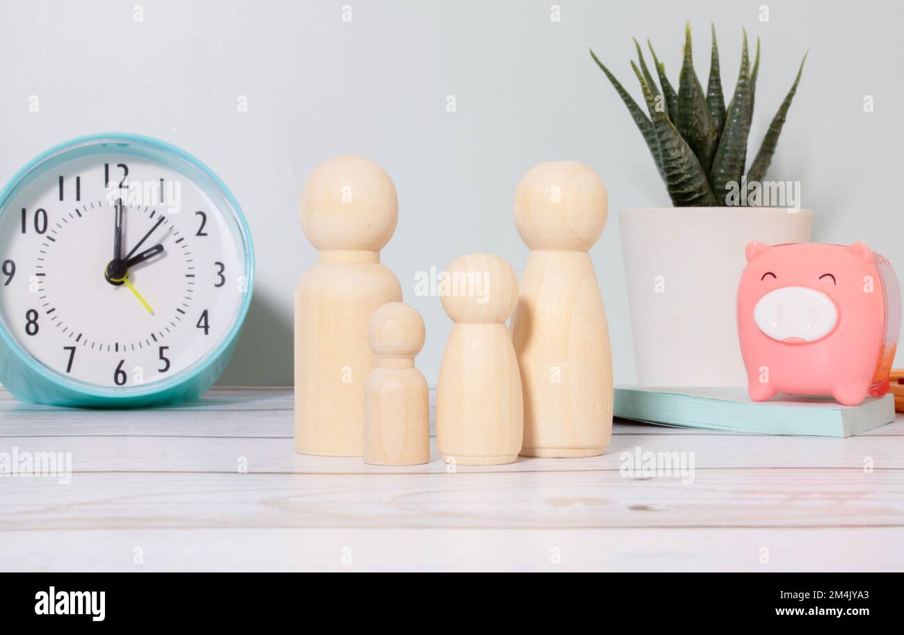 Family icon and house model placed on wooden table and green background ...