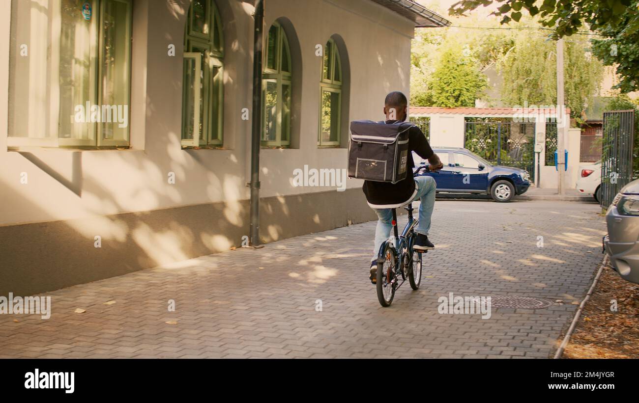 African american male courier delivering takeaway meal order, riding ...