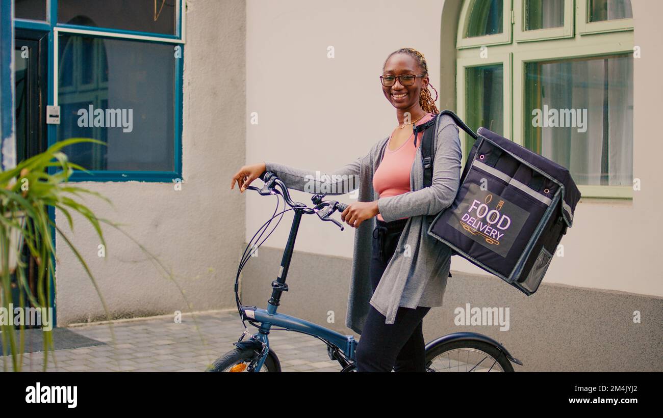 African american female carrier waiting to customer outdoors, standing ...