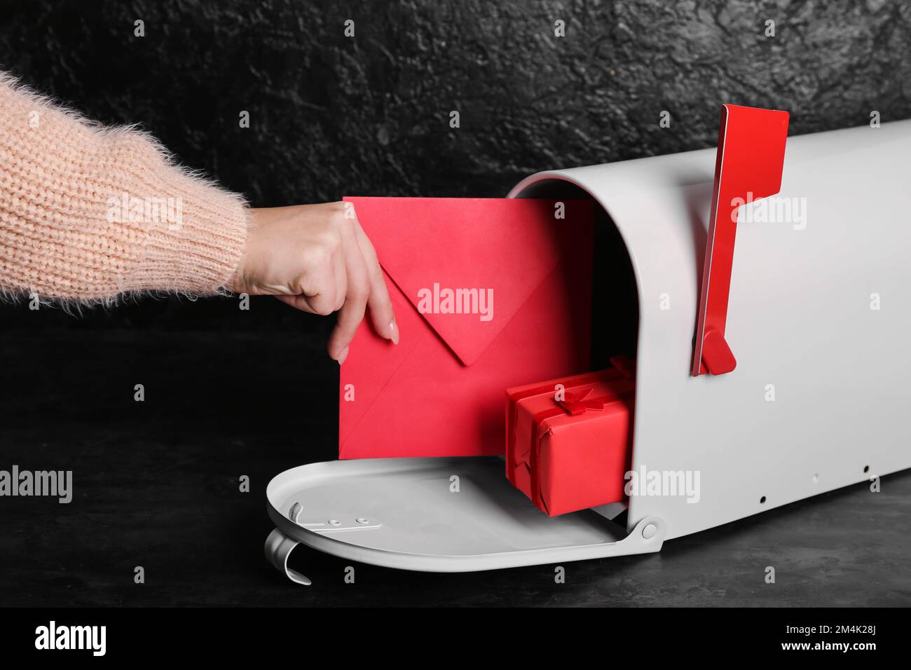 Woman taking letter from mailbox on dark background. Valentine's Day ...