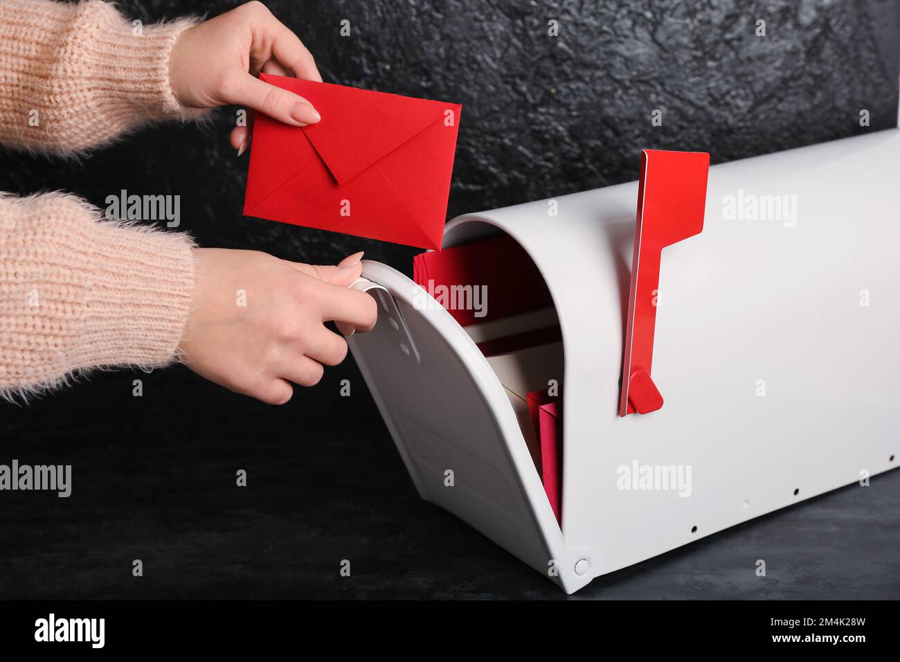 Woman taking letter from mailbox on dark background. Valentine's Day ...