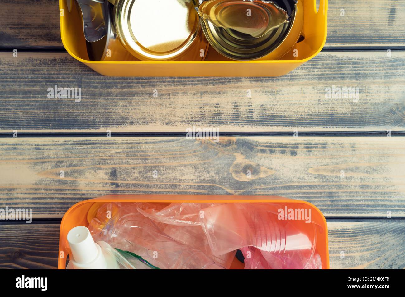 Two halves of containers with metal canned goods and plastic waste on ...
