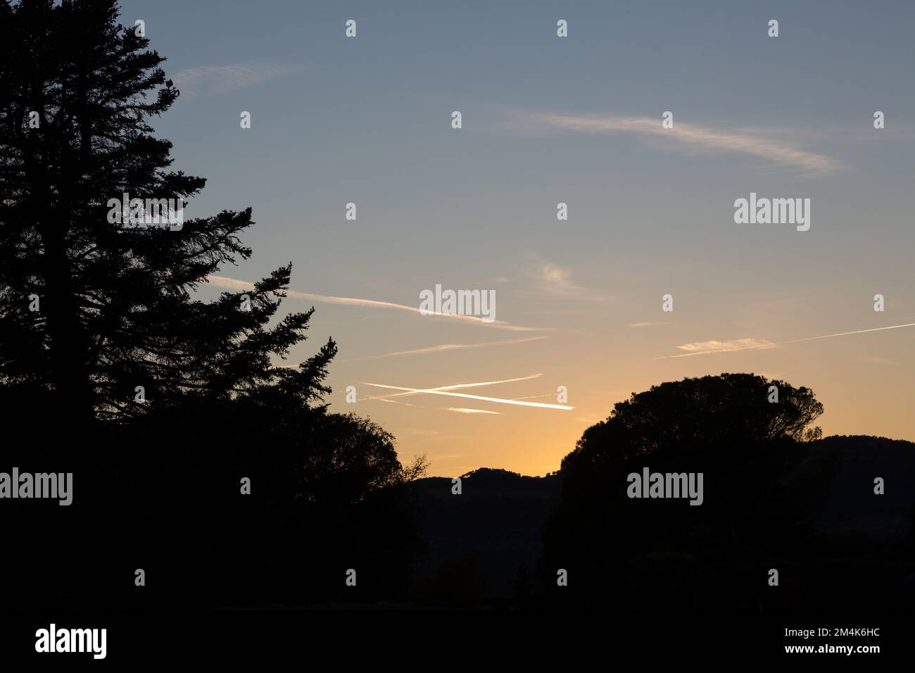 sky streaked by aircraft trails at dusk in the autumn season Stock ...