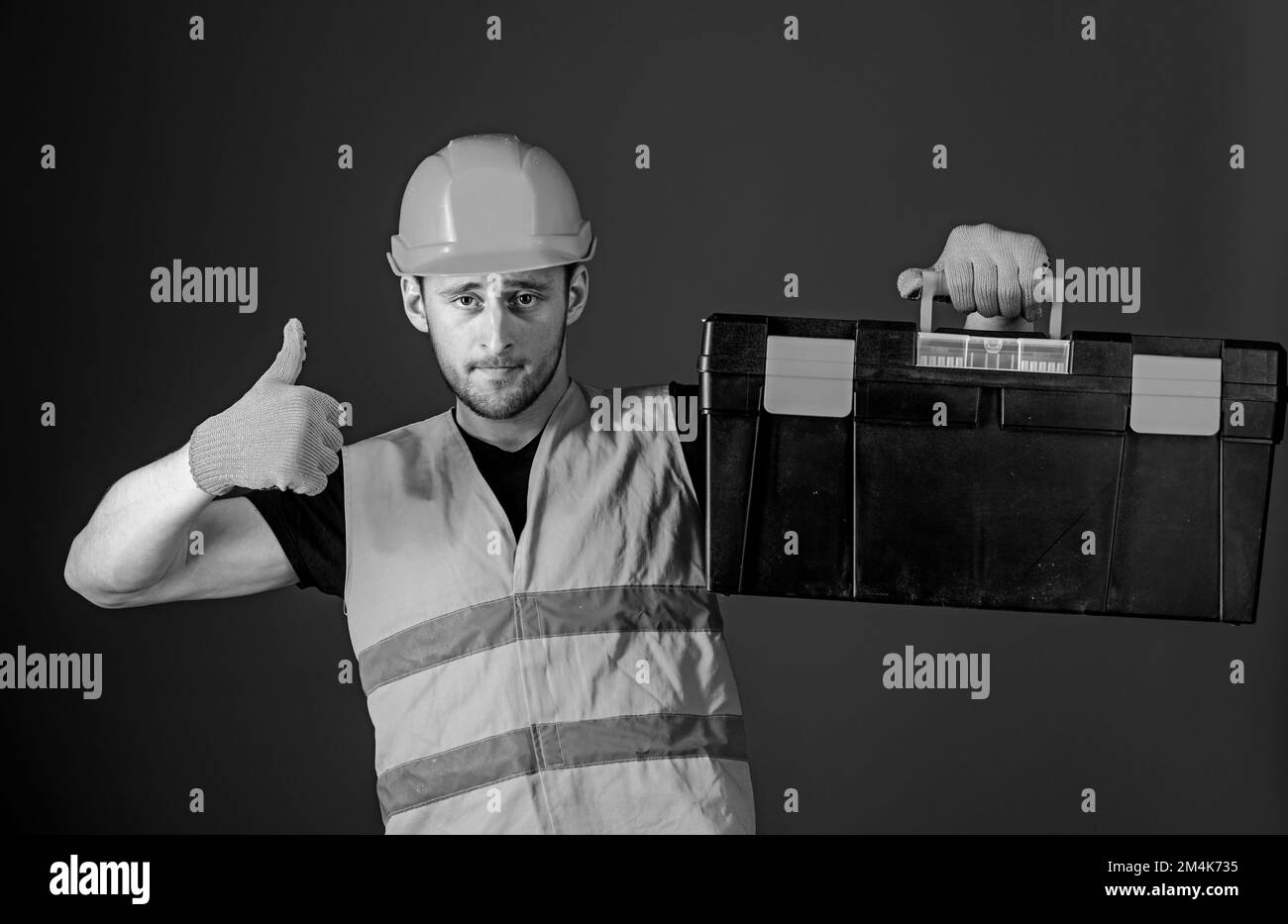 Worker, repairer, repairman, builder on confident face carries toolbox ...