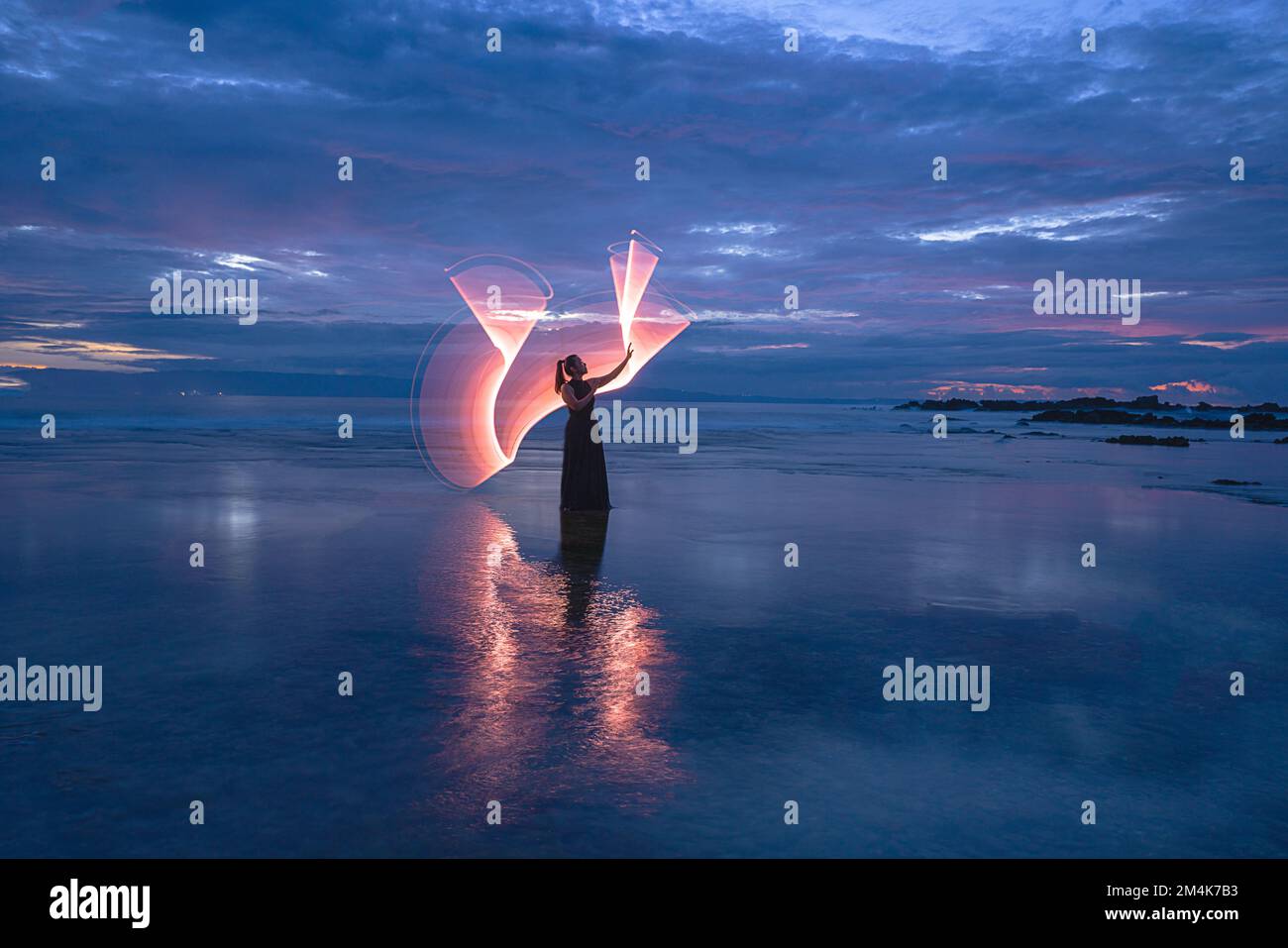 A female light painting model on sandy Tanjung Layar Beach during ...