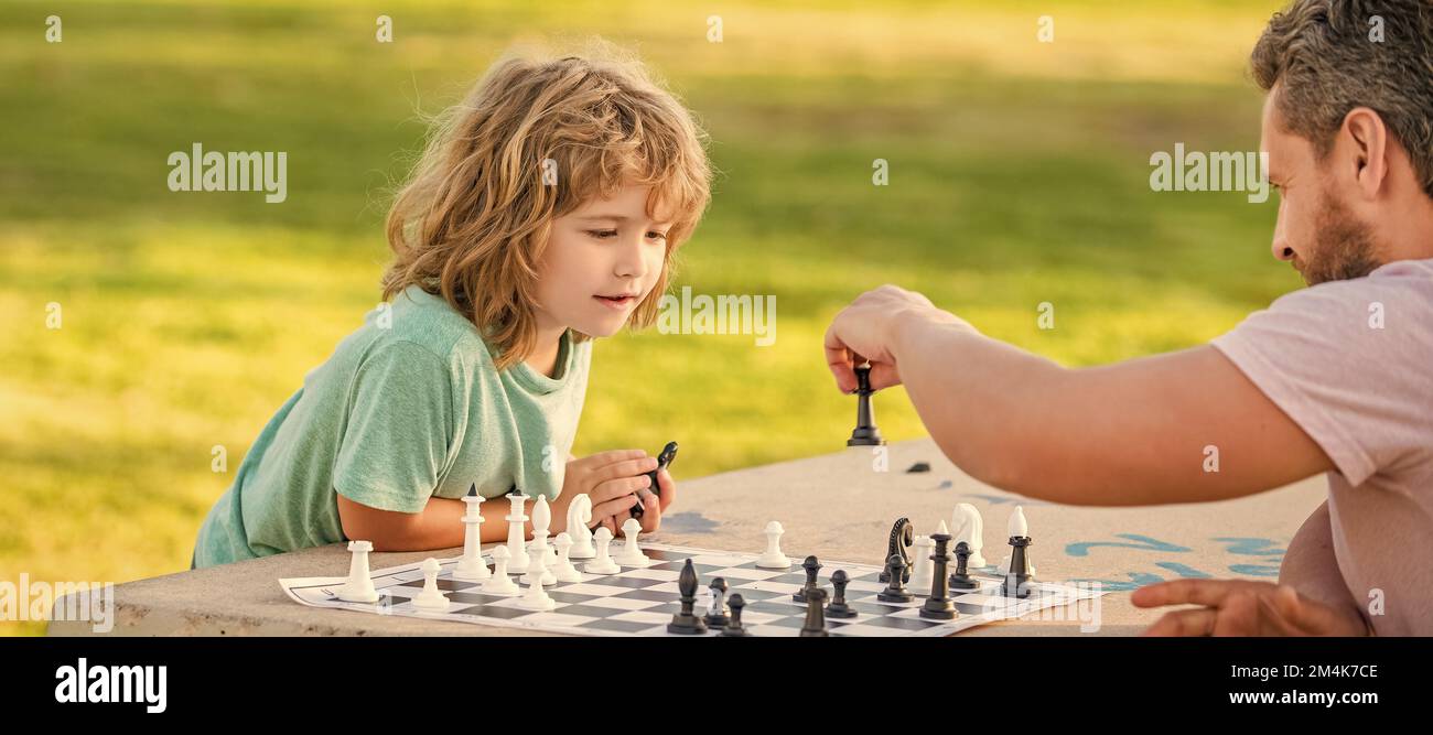 Father and son play chess outdoor, banner poster with copy space ...