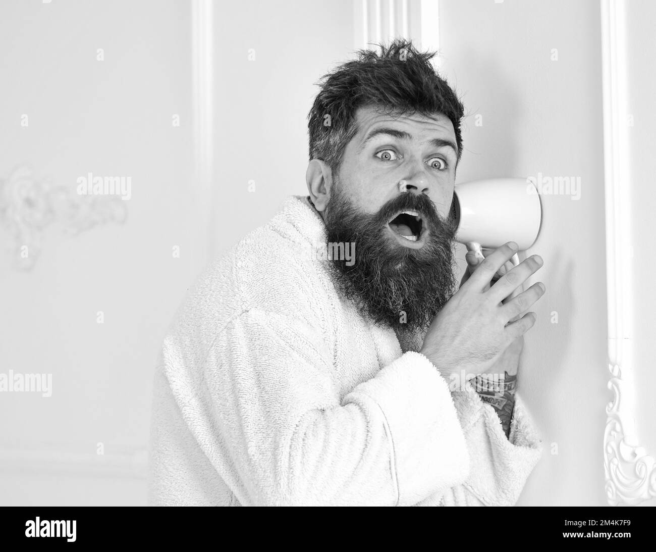 Hipster in bathrobe on shocked face secretly listen conversation ...