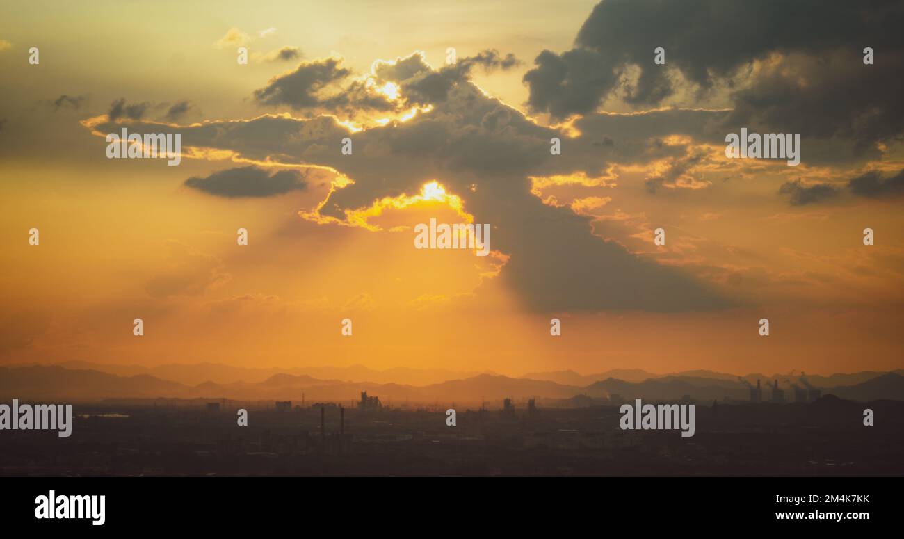 The beautiful golden sunset hiding behind the clouds and shining over ...
