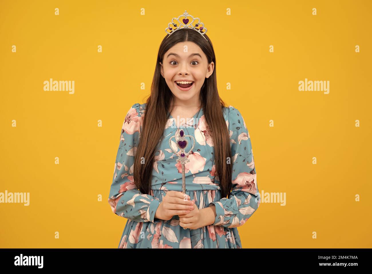 Portrait of happy girl princess in tiara holding magic wand. Teenager ...
