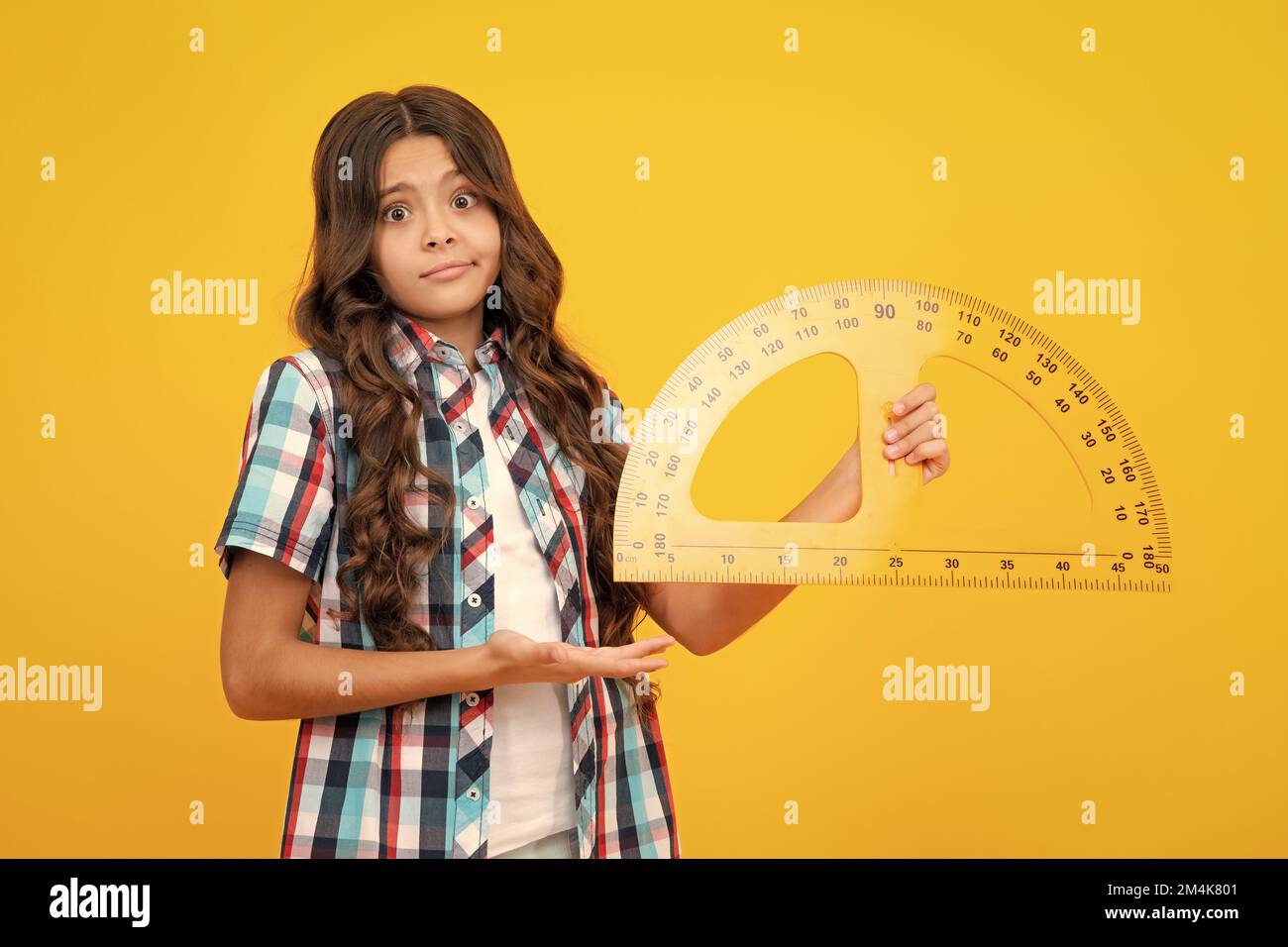 Back to school. School girl hold ruler measuring isolated on yellow ...