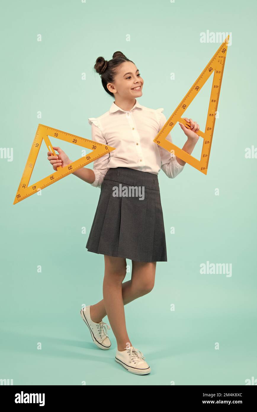 School girl holding measure for geometry lesson, isolated on blue ...