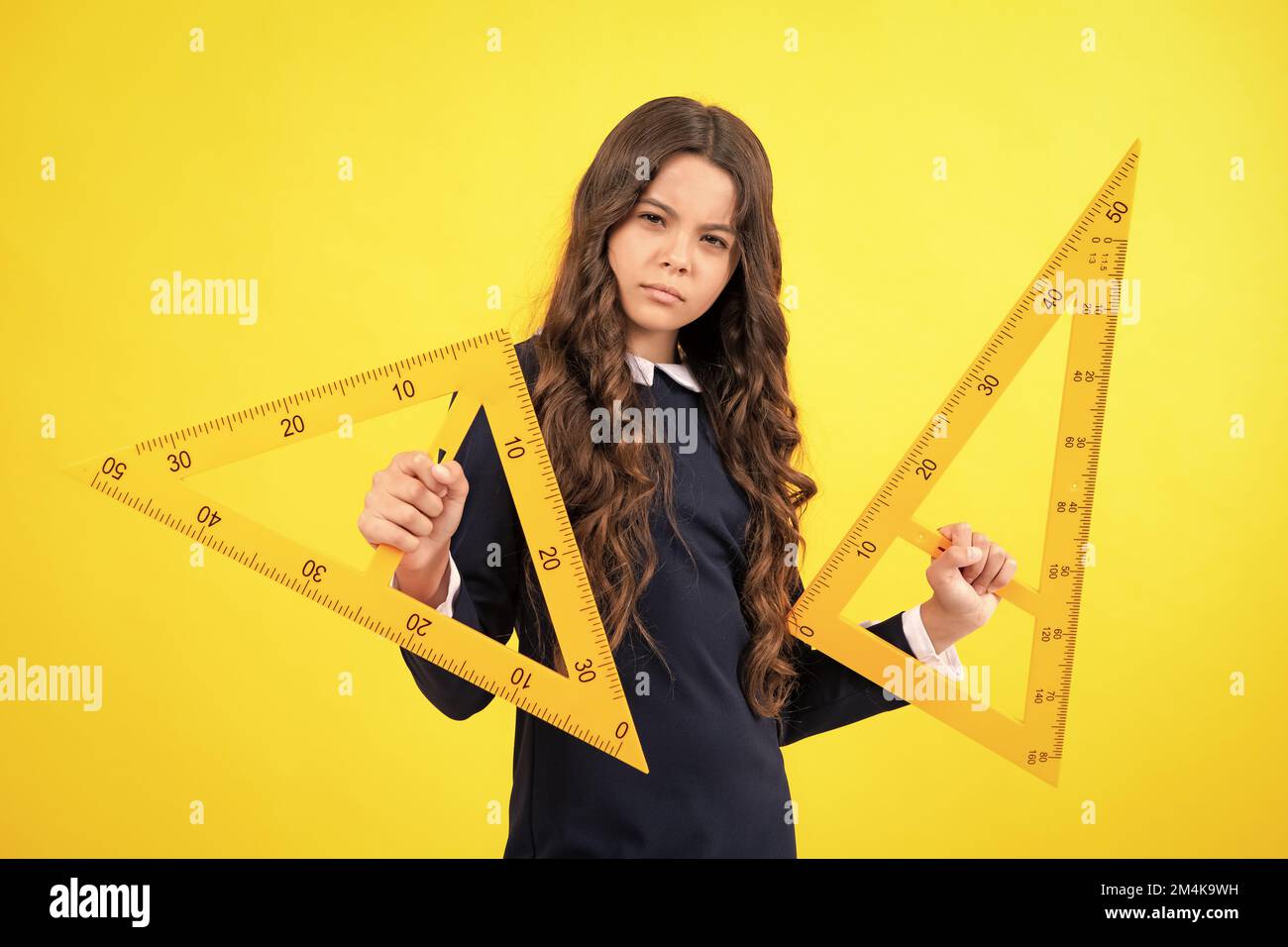 Back to school. School girl hold ruler measuring isolated on yellow ...