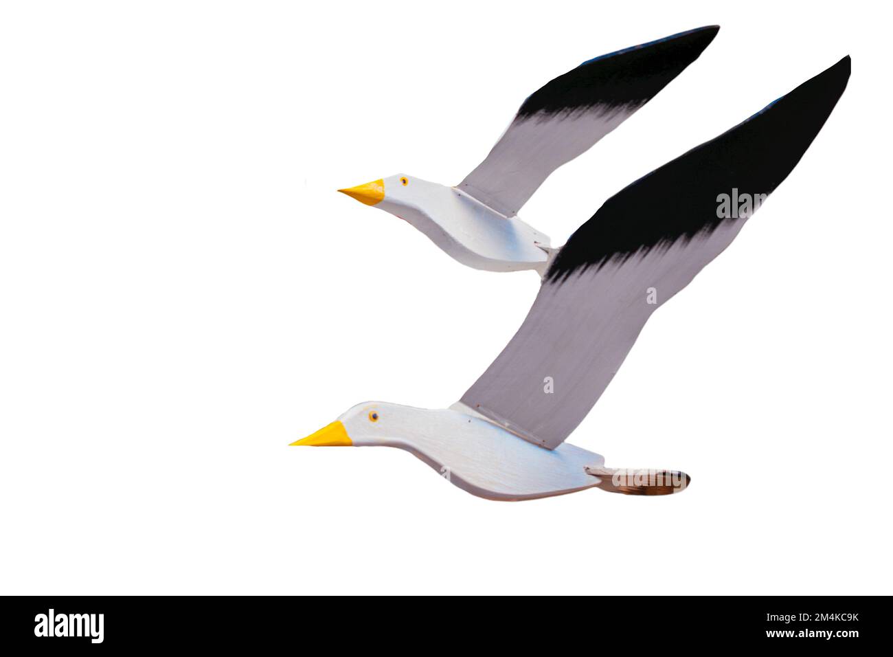 Two handmade seagull figures flying isolated on a white background ...