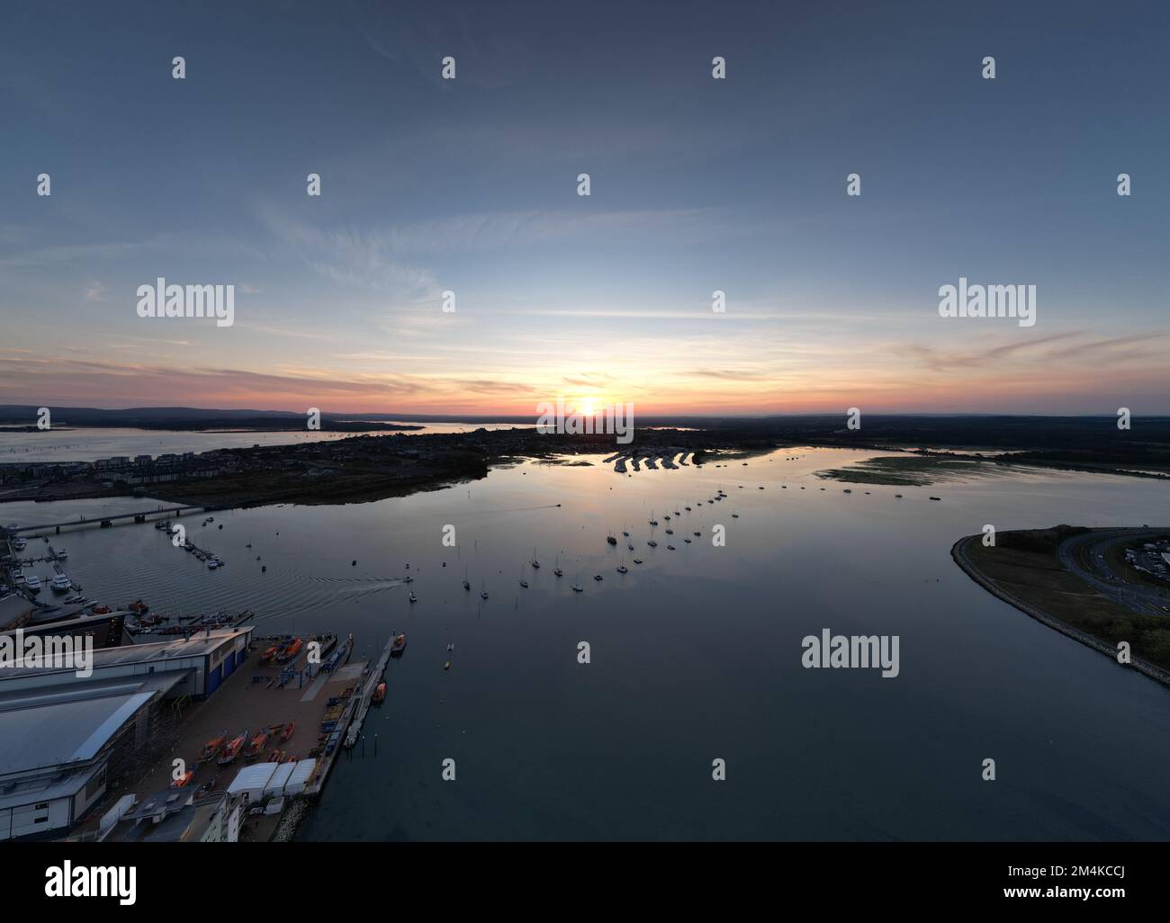An aerial view of boats in a harbor before a blue-shaded sunset sky in ...