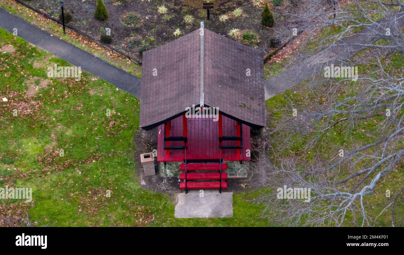 An aerial view of a red hut in an empty park on a cloudy day in autumn ...