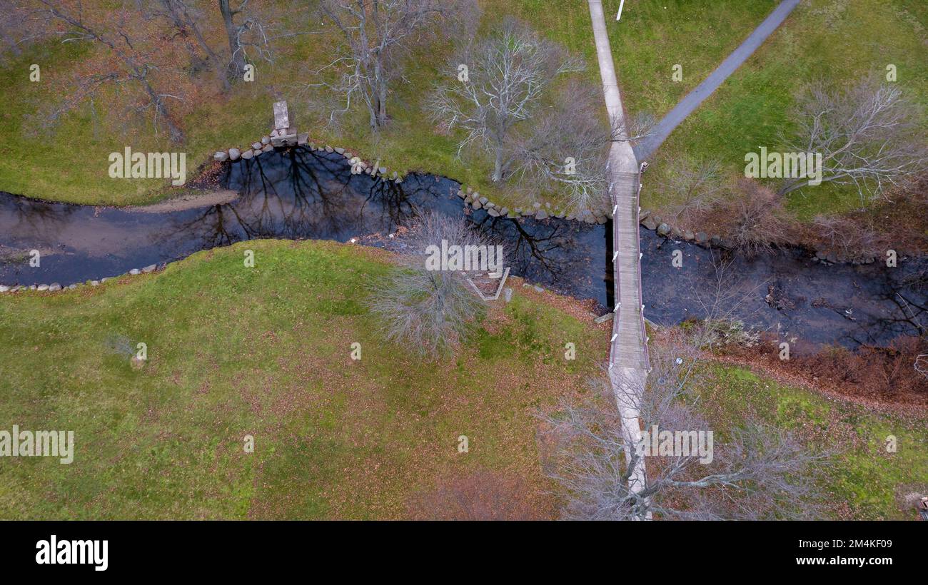 An aerial view of a park with a reflective stream, paths and a ...