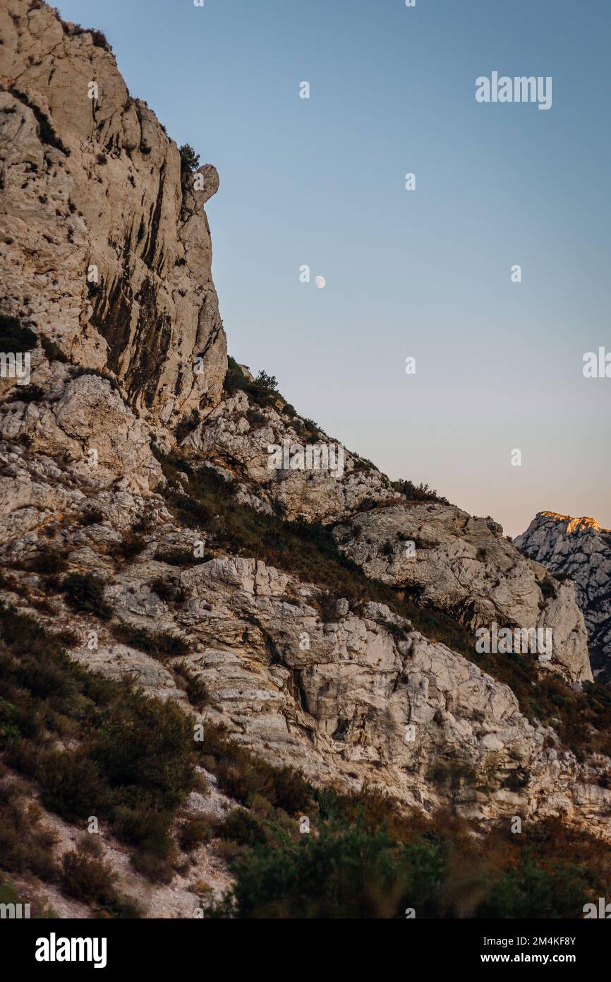 A vertical view of the Massif des Calanques with the moon in the blue ...
