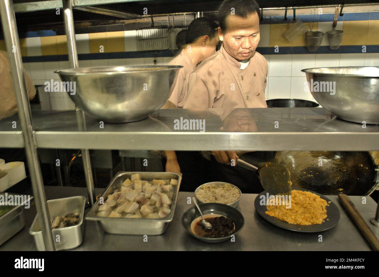 A chef is preparing halal food at the kitchen of an Islamic cafe ...