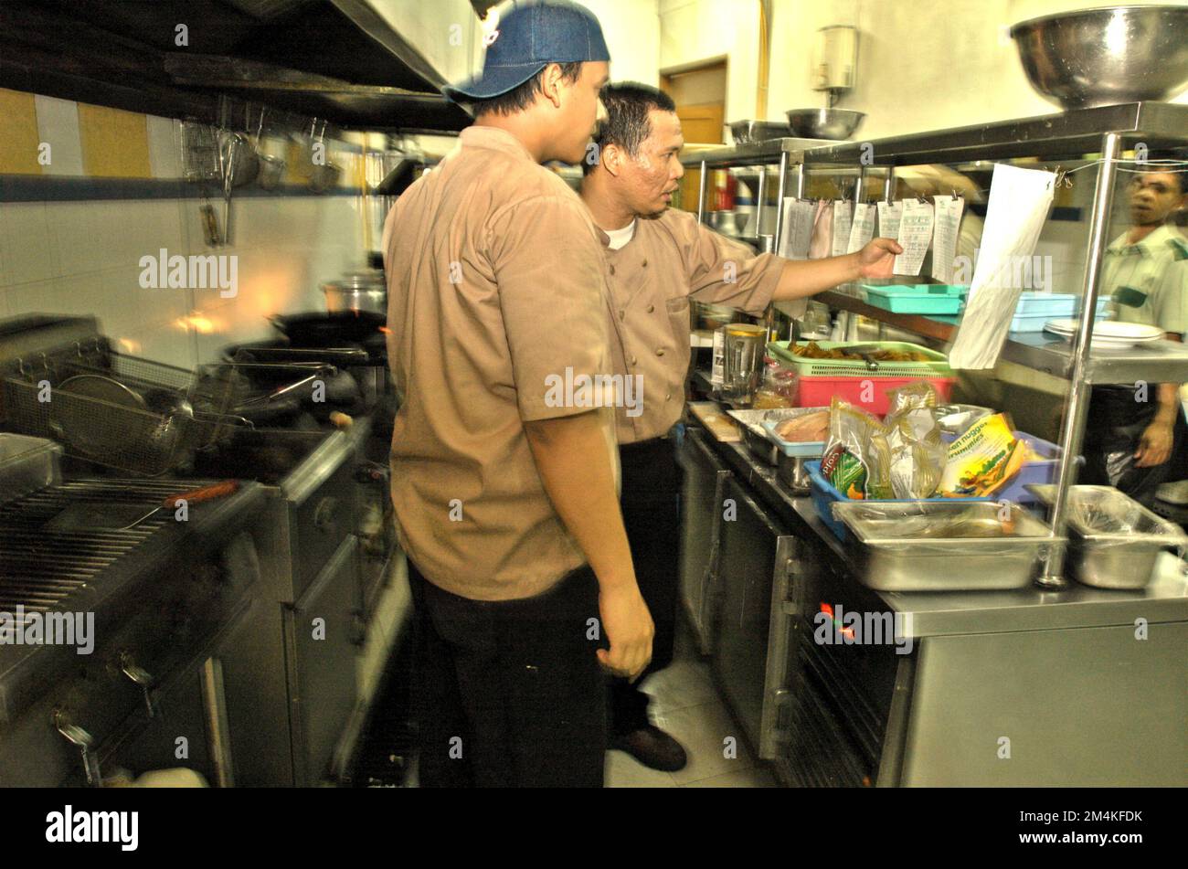 Chefs are preparing halal foods at the kitchen of an Islamic cafe ...