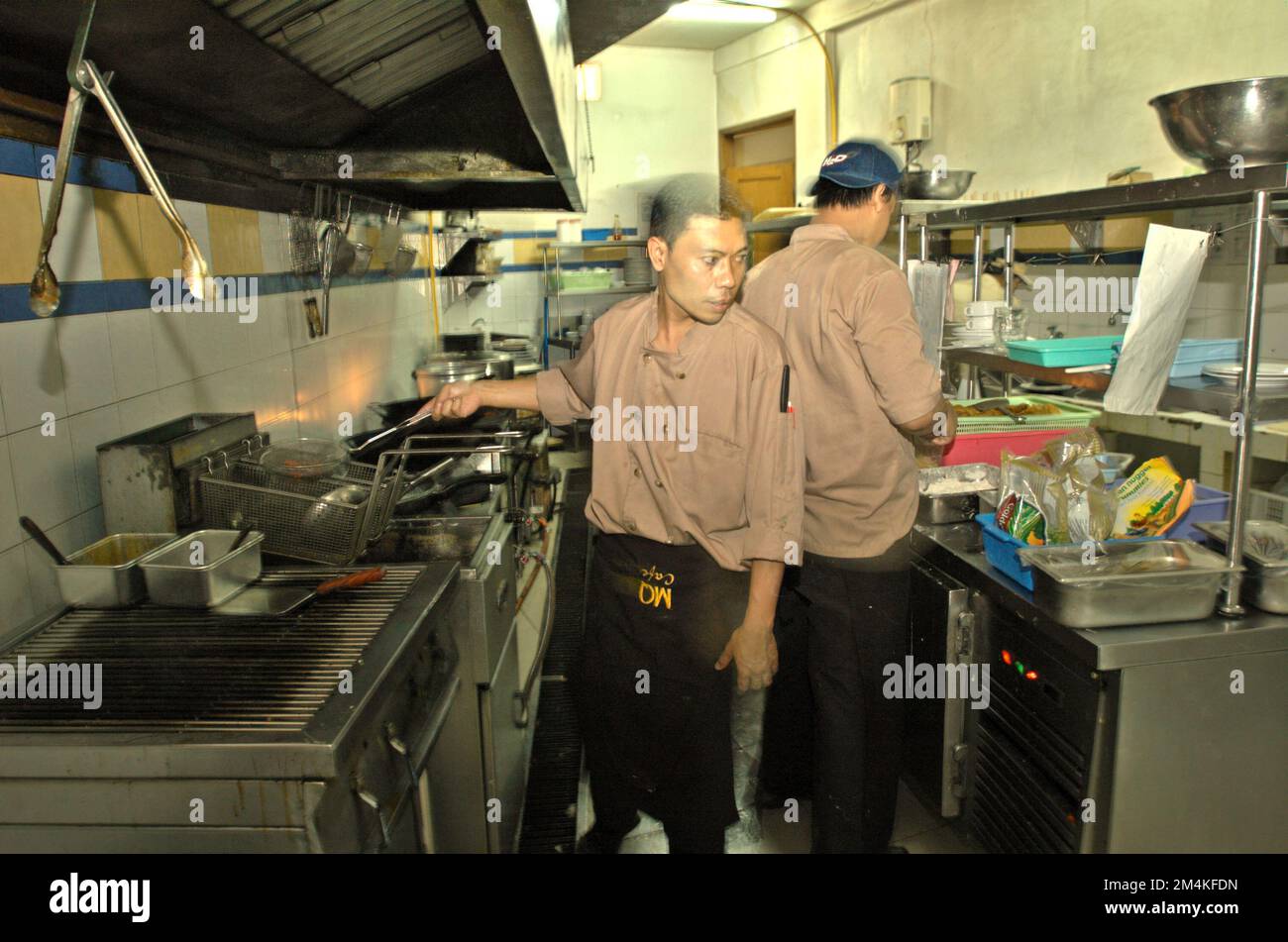 Chefs are preparing halal foods at the kitchen of an Islamic cafe ...