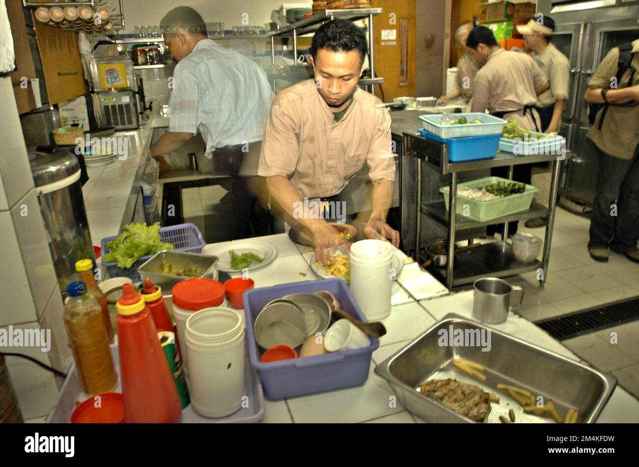 Chefs are preparing halal foods at the kitchen of an Islamic cafe ...