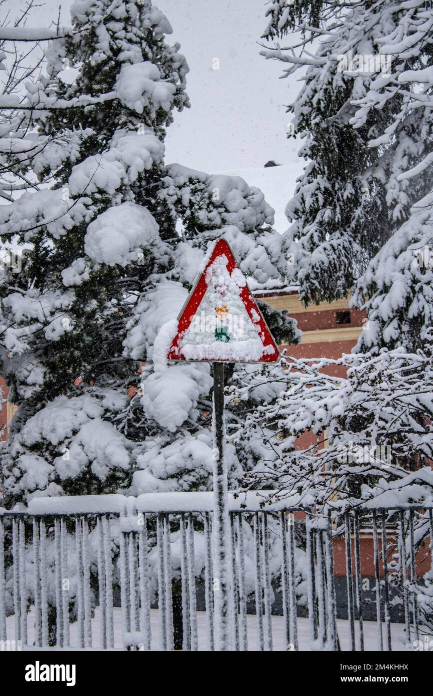 A vertical shot of a frozen traffic light sign covered in snow Stock ...