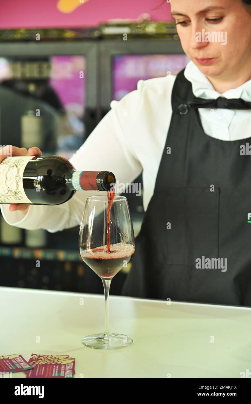 A closeup view of a female wine steward pouring red wine Stock Photo ...