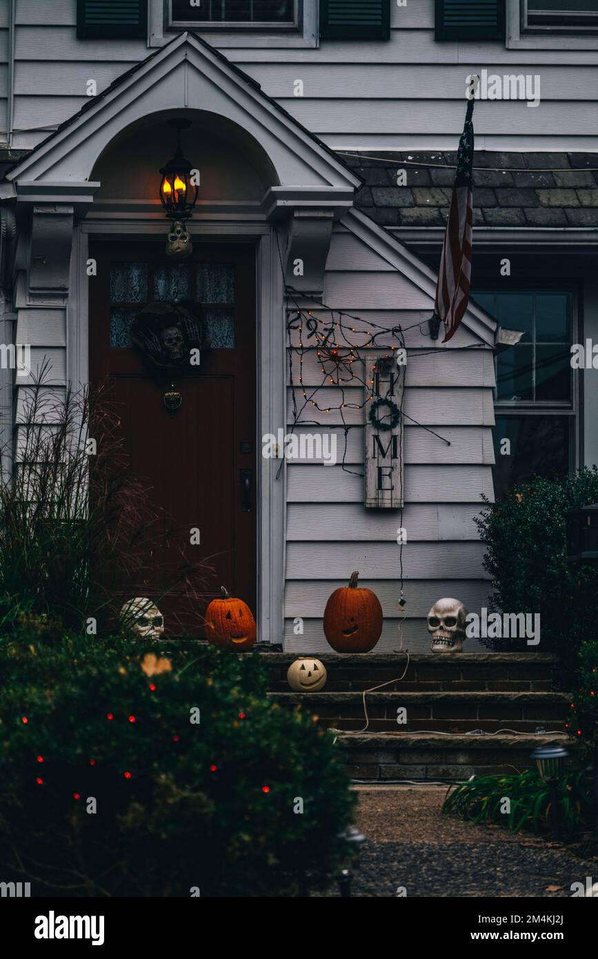 Many colorful Halloween decorations, skeletons, scarecrows at driveway ...