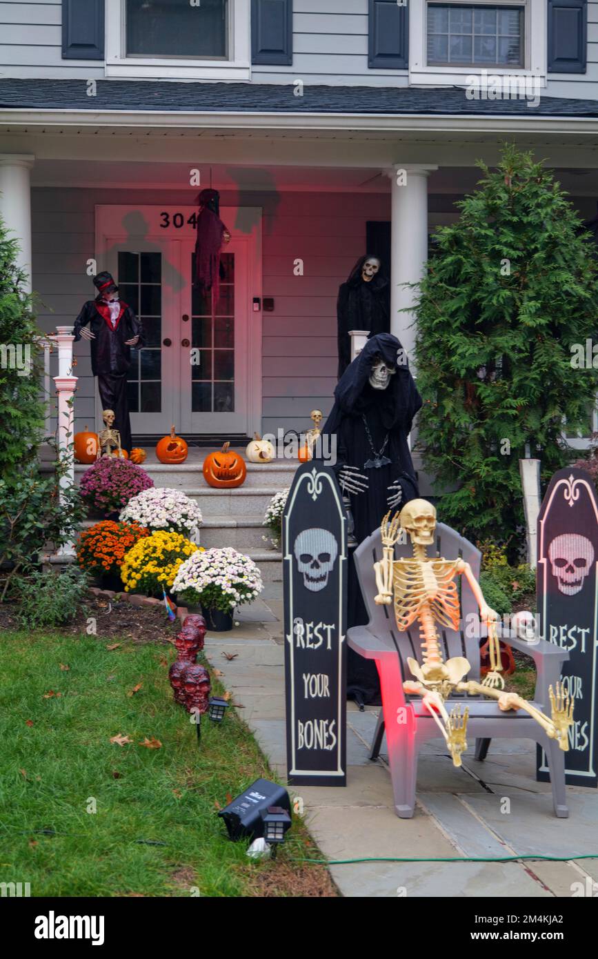 Many colorful Halloween decorations, skeletons, scarecrows at driveway ...