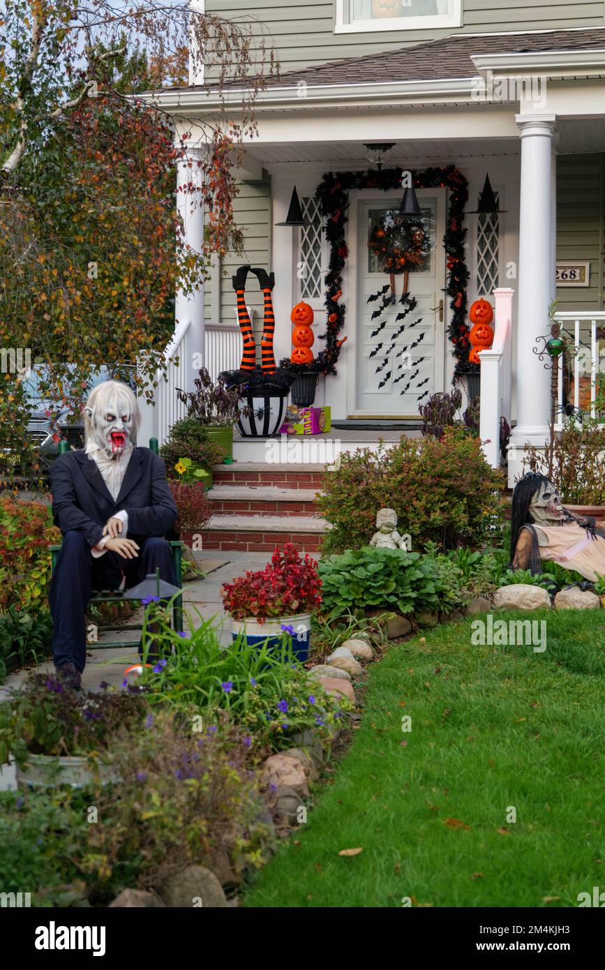 Many colorful Halloween decorations, skeletons, scarecrows at driveway ...