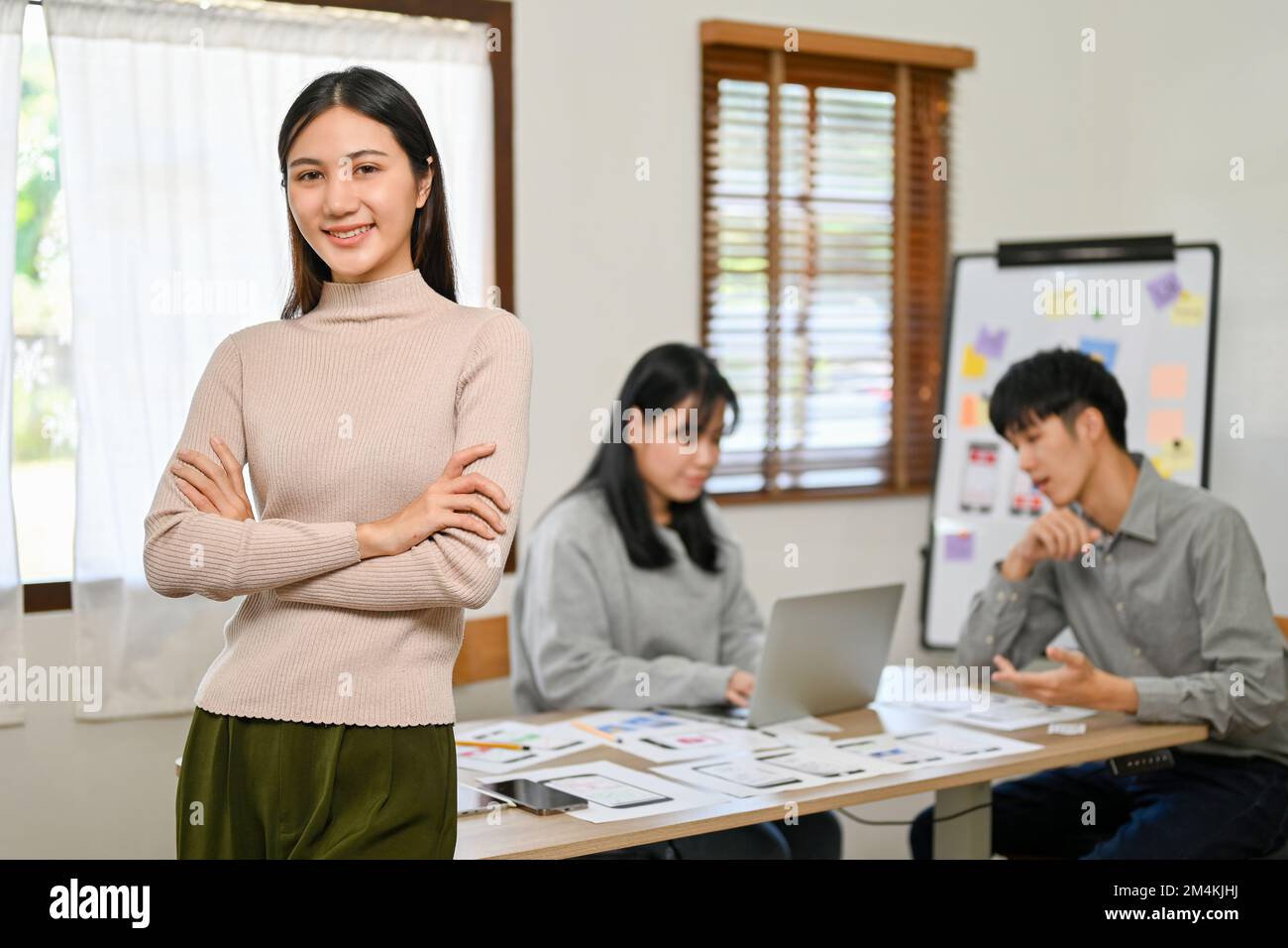 Successful and confident millennial Asian female boss stands with her ...