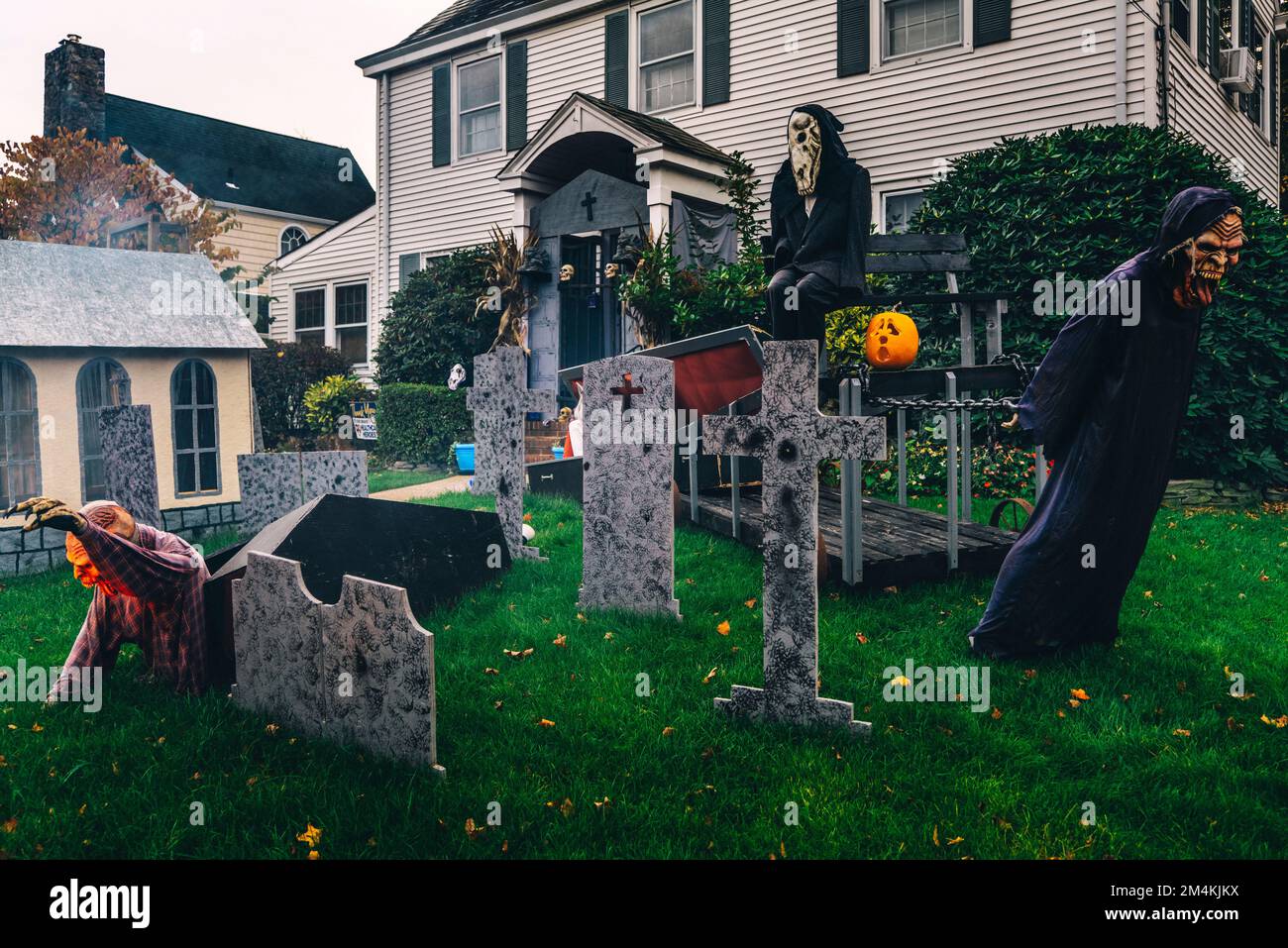 Many colorful Halloween decorations, skeletons, scarecrows at driveway ...