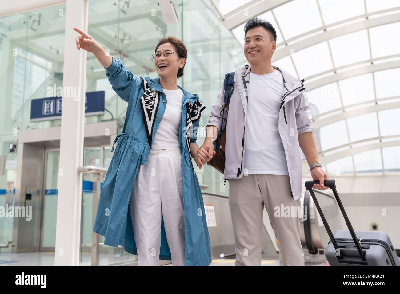 Happy elderly couple take the elevator at the airport Stock Photo - Alamy