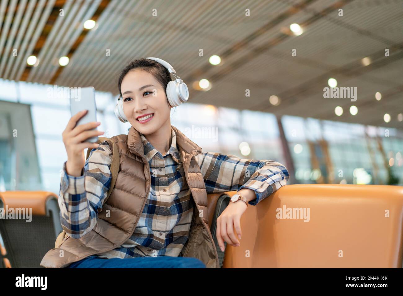 A young woman in the airport lounge with mobile phones Stock Photo - Alamy
