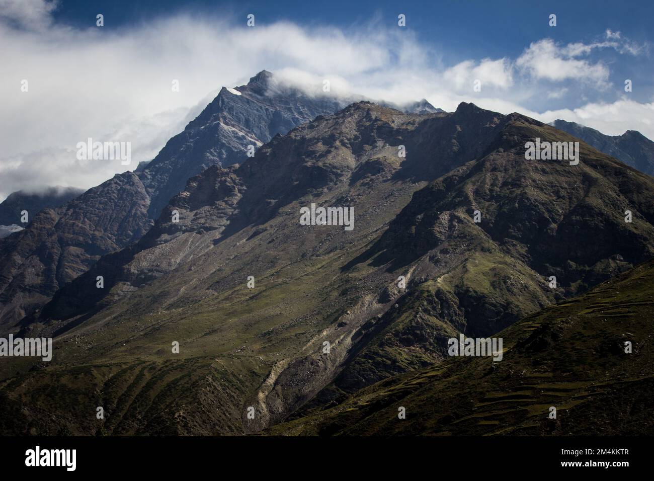 A landscape of a green mountain with foggy sky and white clouds at ...