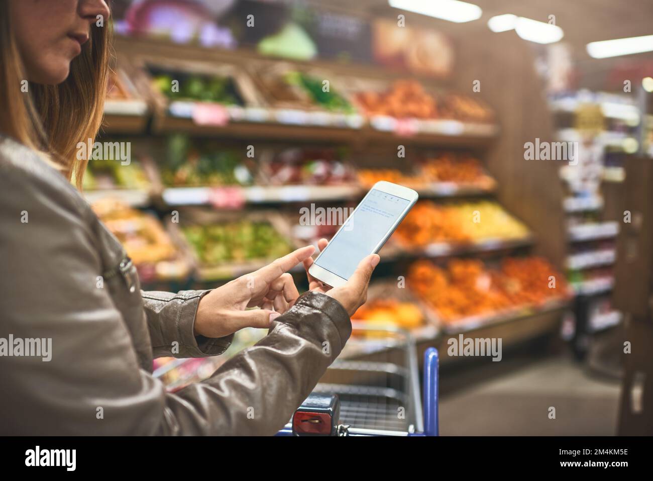 Keeping tabs on everything she buys with mobile tech. a woman using a ...